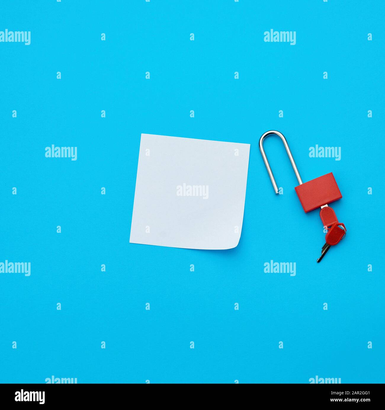 white paper and metal open padlock with keys on a blue background, copy ...