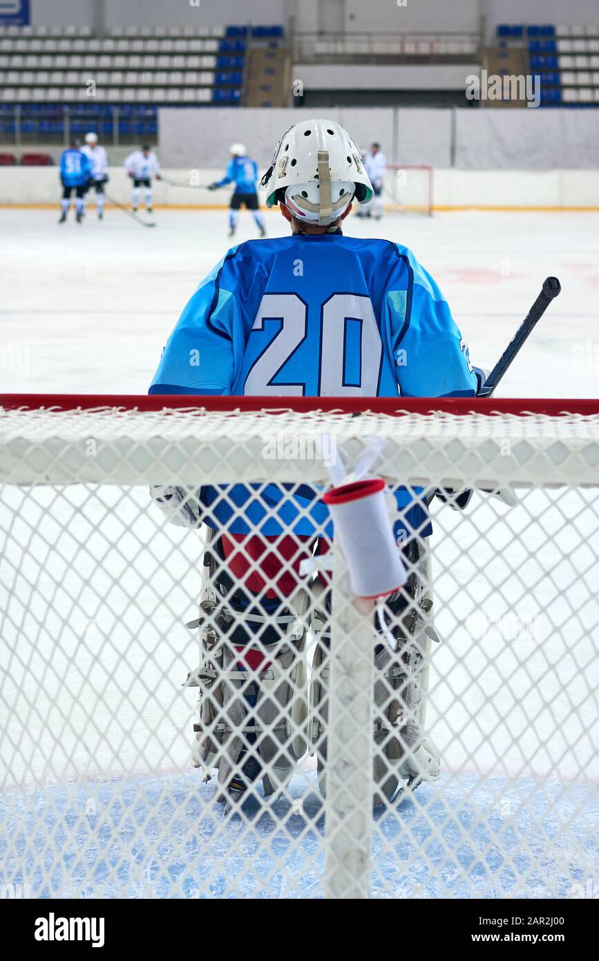 hockey goalie in blue uniform on goal Stock Photo - Alamy