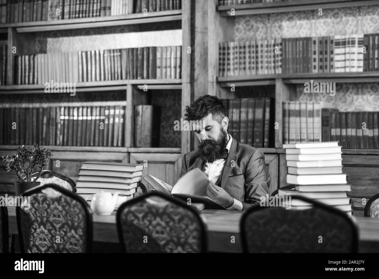 Historian sits in library and reads old books. Historical research ...