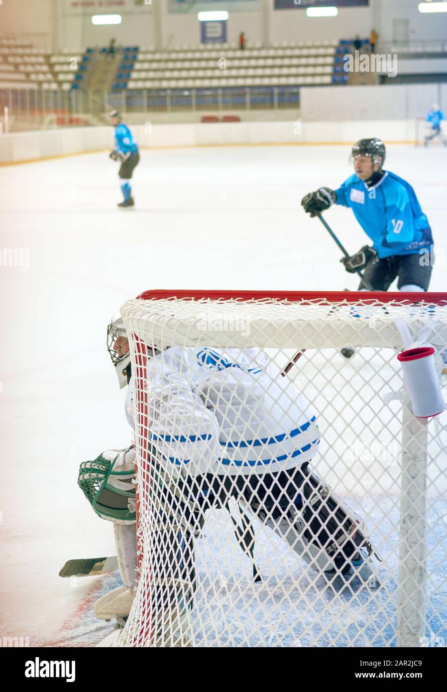 hockey goalie in blue uniform on goal Stock Photo - Alamy