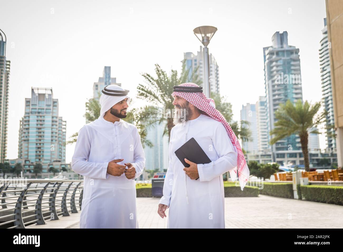 Two businessmen with traditional emirates clothes meeting in Dubai ...