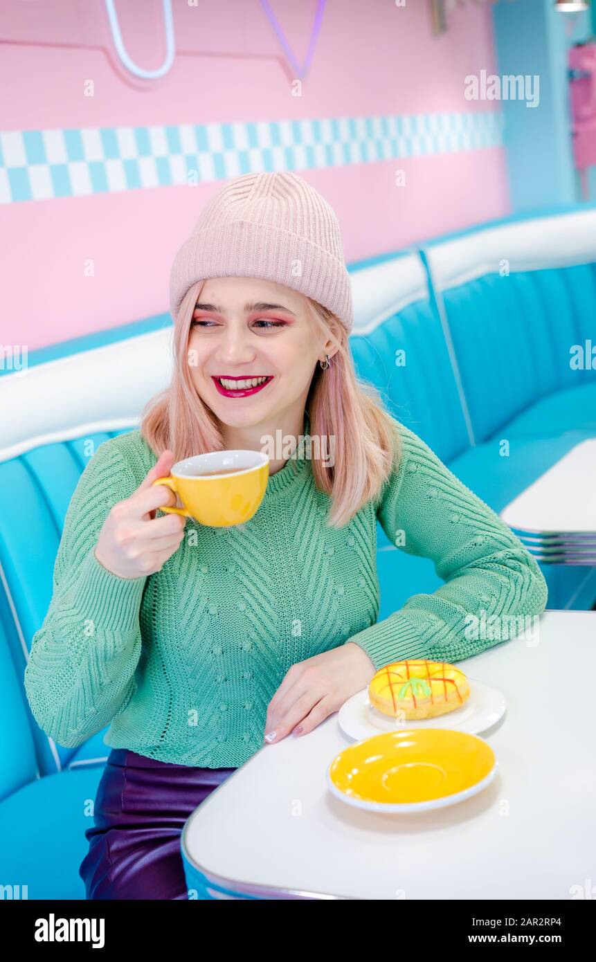 Good looking young woman with light hair drinking tea in a cafe. Spring ...