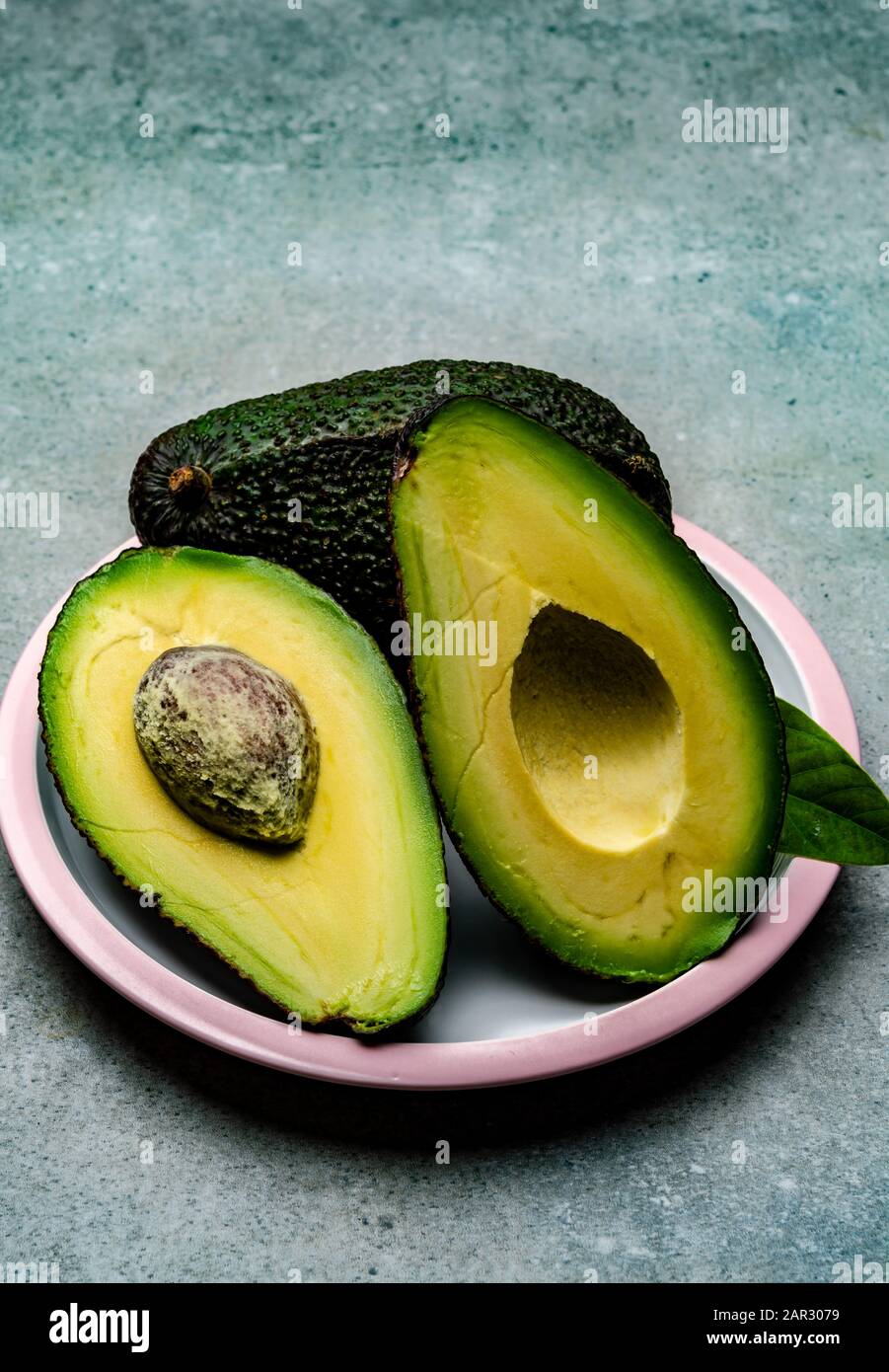 New harvest of fresh ripe hass avocado close cut in half with seed ...