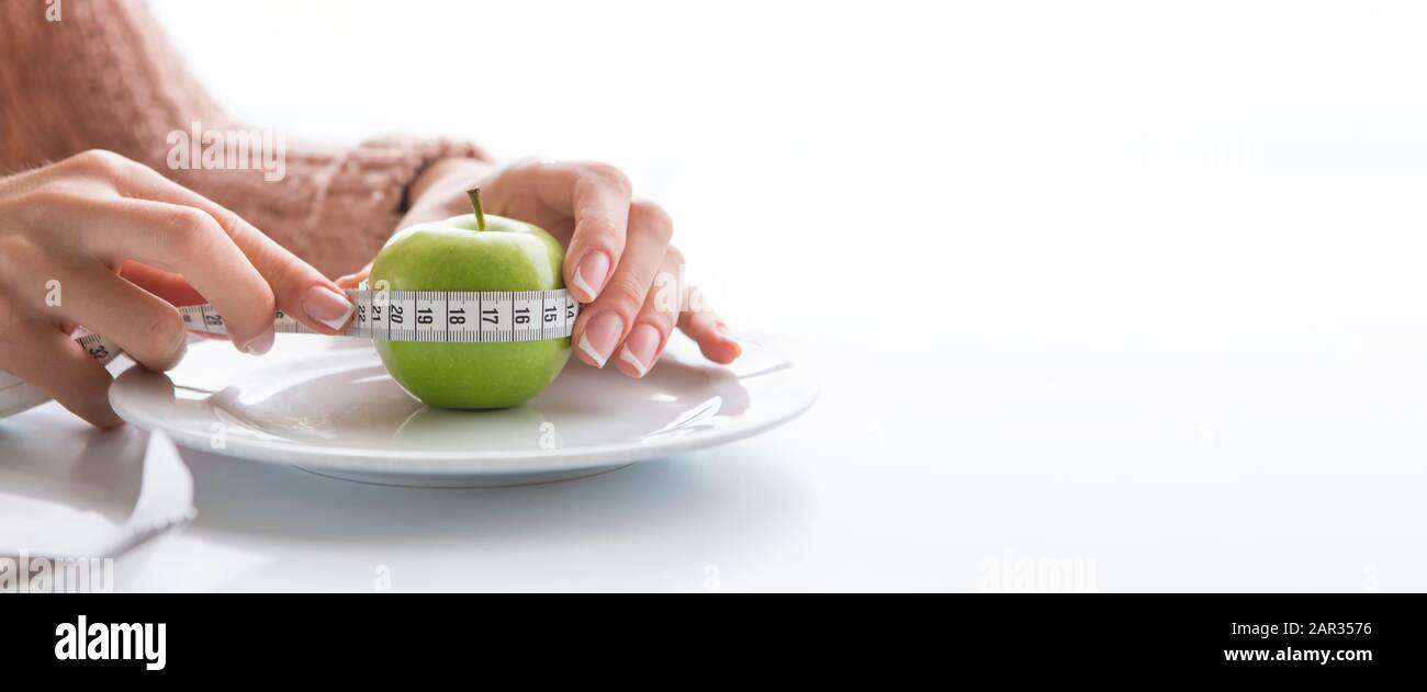 woman measures the circumference of the apple with tape measure Stock ...
