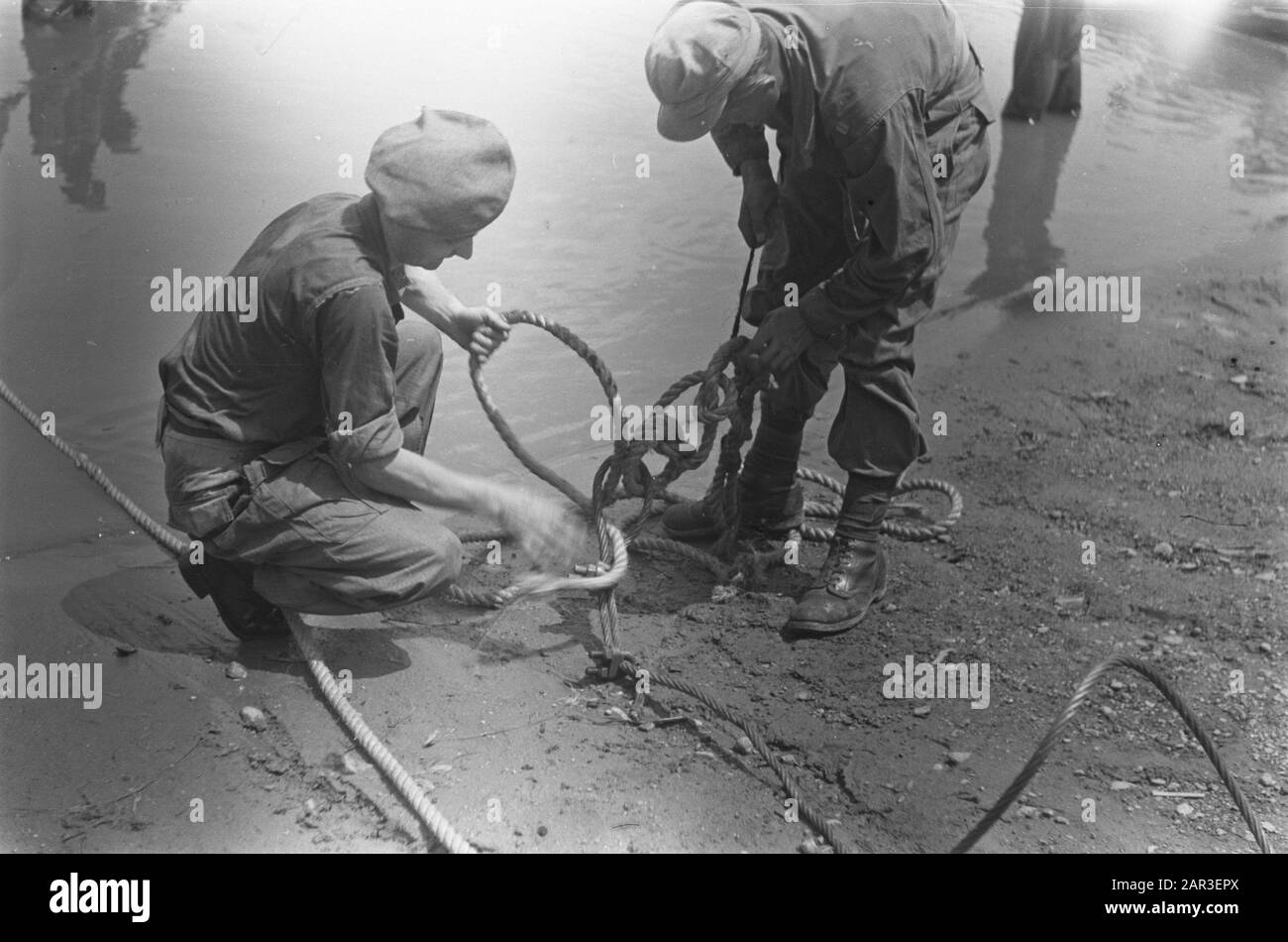 [two soldiers engaged in untangle or knotting a thick rope] Date: 1948 ...