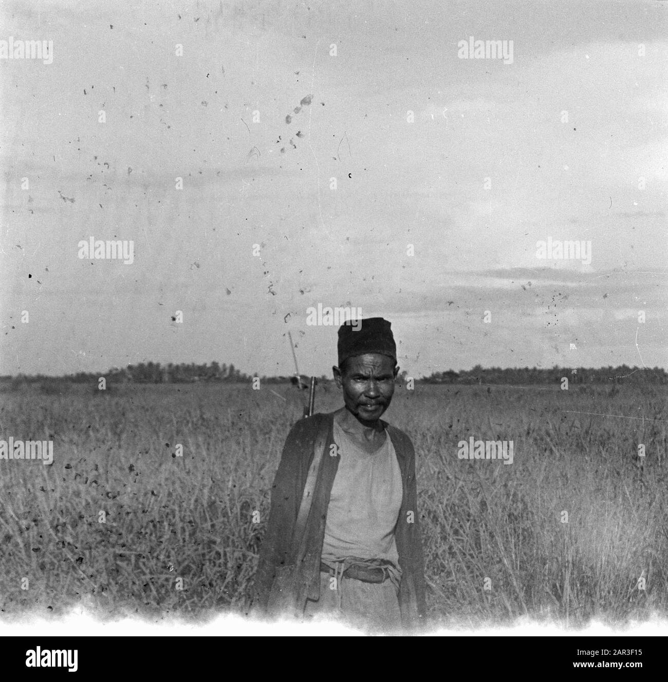 Indonesian man standing in a rice field? His clothes are smeared with ...
