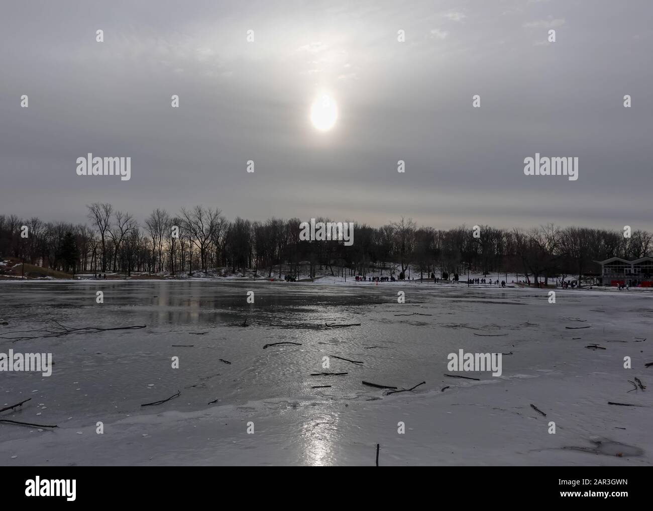 sun covered by clouds sunlight reflecting to the ice sheet of a lake in ...