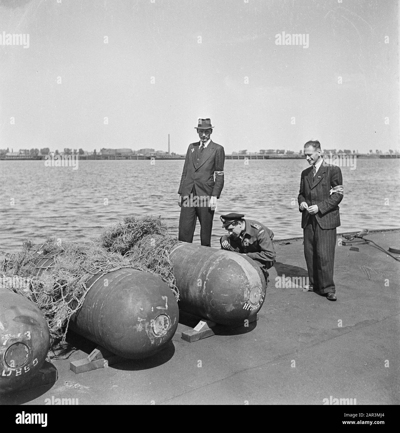 Devastations: Amsterdam port Men on a pontoon view German sea mines Date: May 1945 Location ...