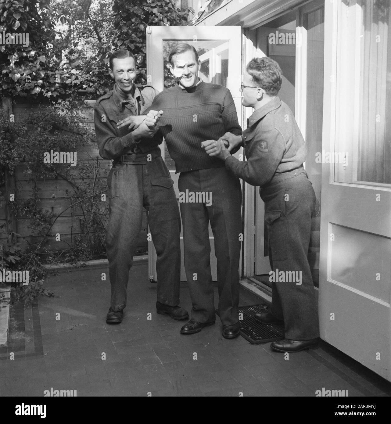 [man with eye wound is supported by two uniformed men] Date: 1945 ...