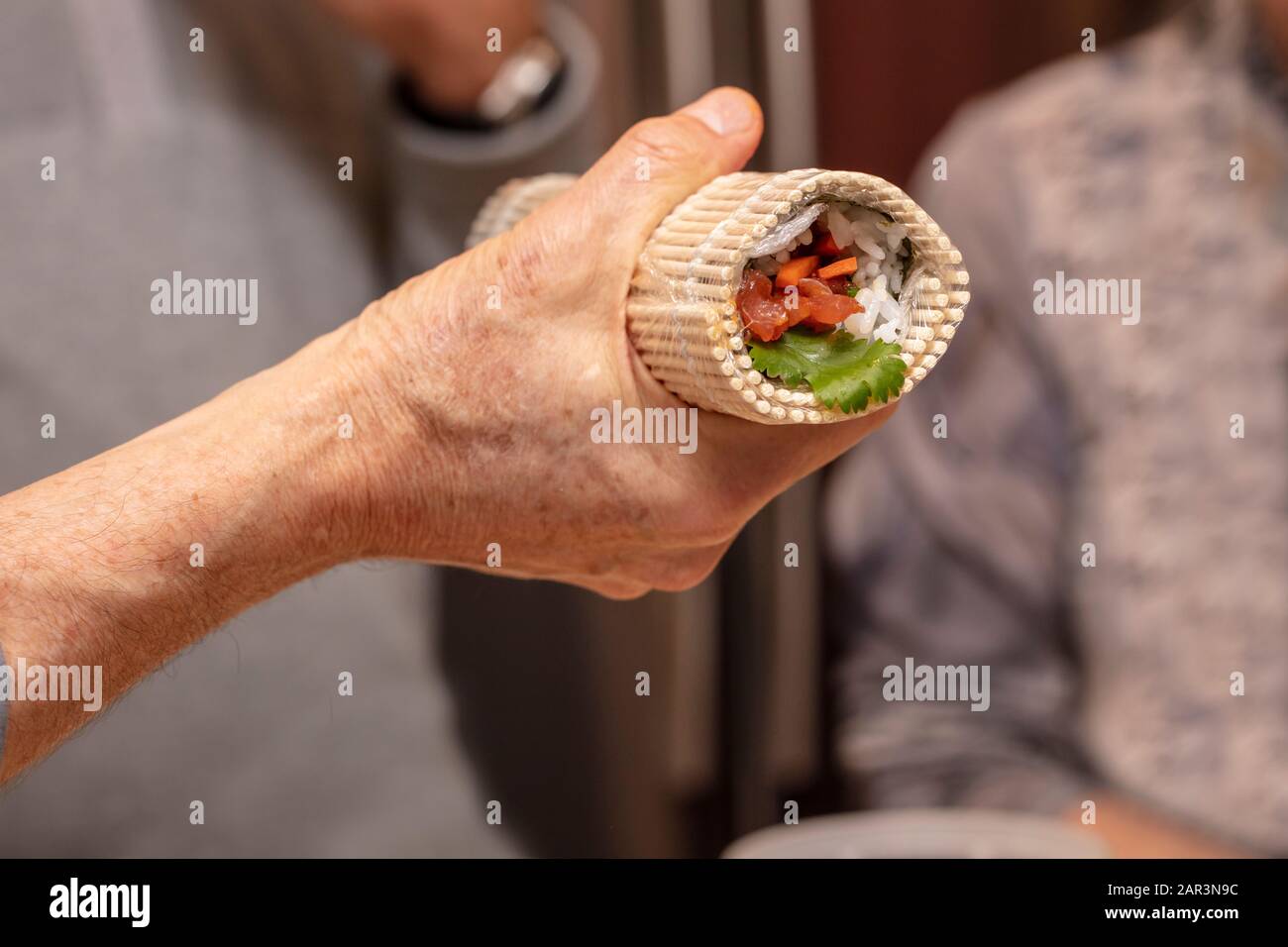 The process of making sushi during a chef's demonstration class in a ...