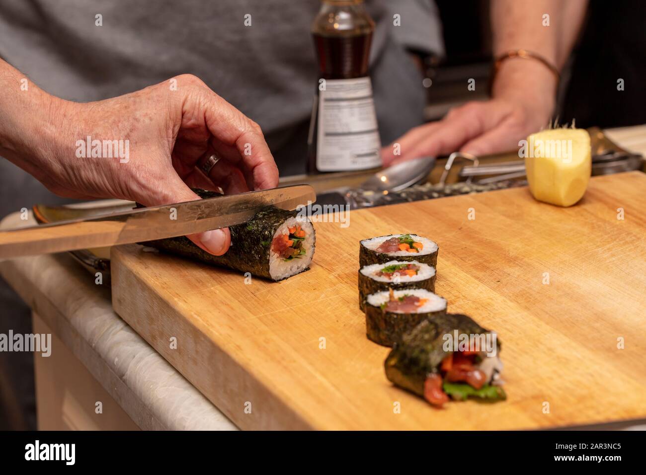 The process of making sushi and slicing during a chef's demonstration ...