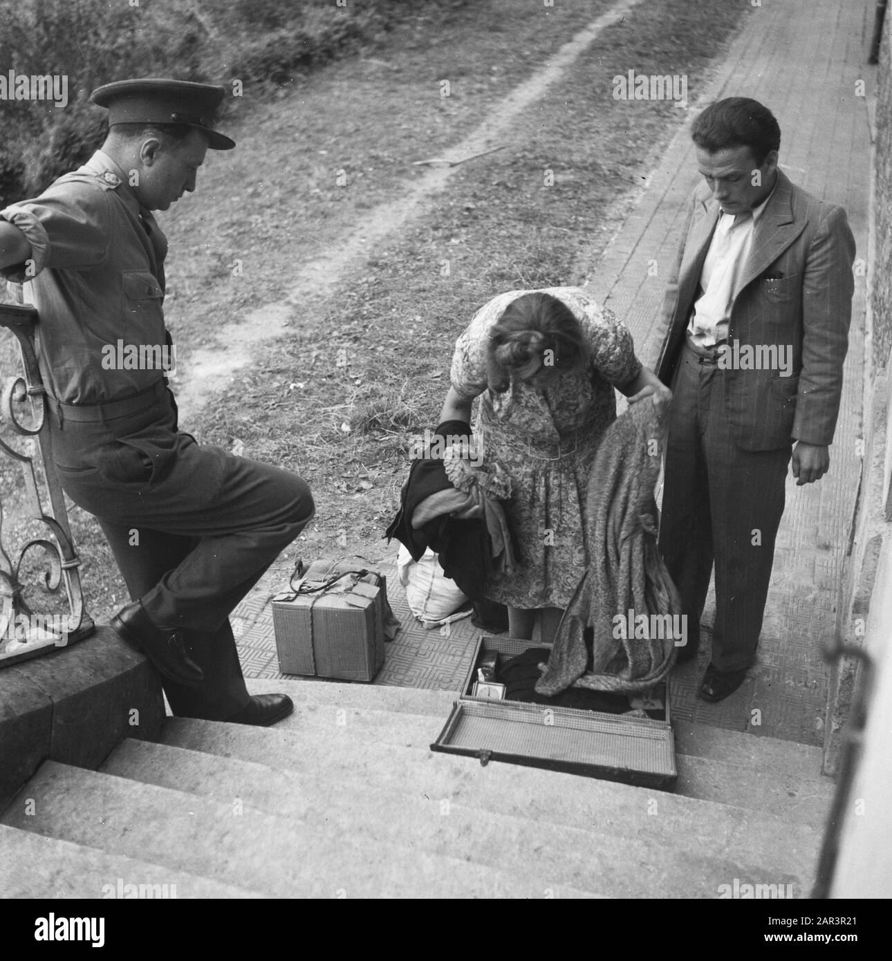 Land Traitors in France Woman takes clothes out of a suitcase under the ...