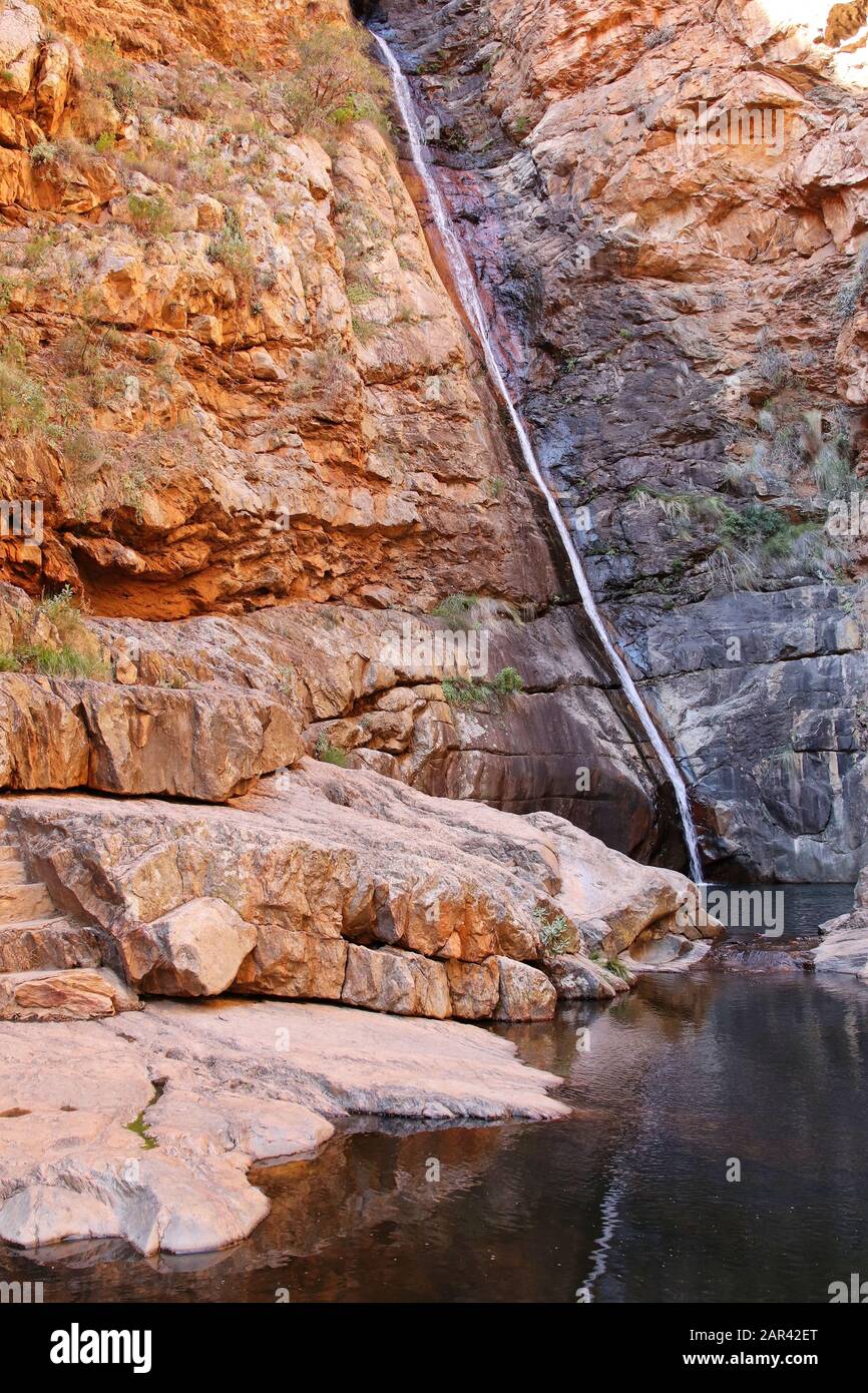 Vertical shot of a waterfall flowing through a rock formation and ...