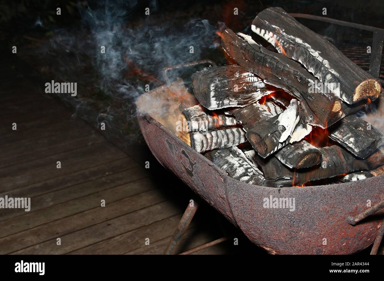 Closeup shot of wood burning in a metal container Stock Photo - Alamy