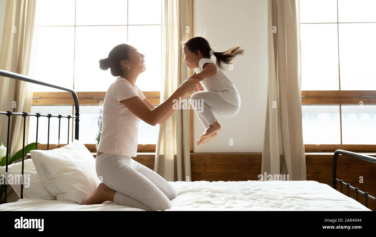 Overjoyed young mum and little daughter play at home Stock Photo - Alamy