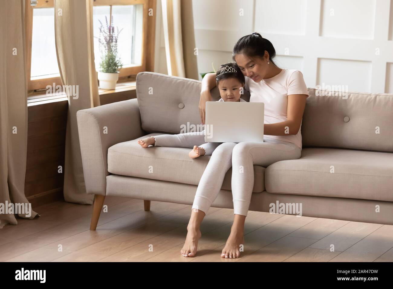 Young ethnic mom and little daughter use computer together Stock Photo ...