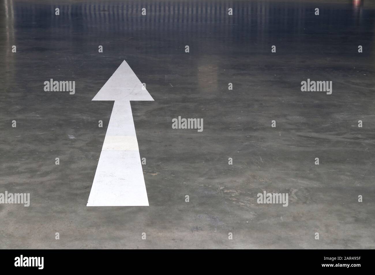 White arrow symbol on polished cement floor Stock Photo - Alamy