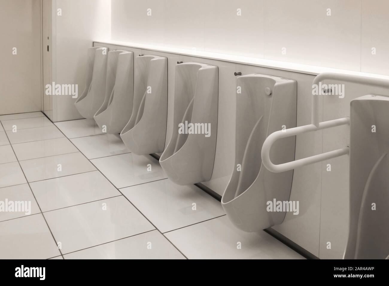 Urinals lined up in white and clean men's toilets Stock Photo - Alamy