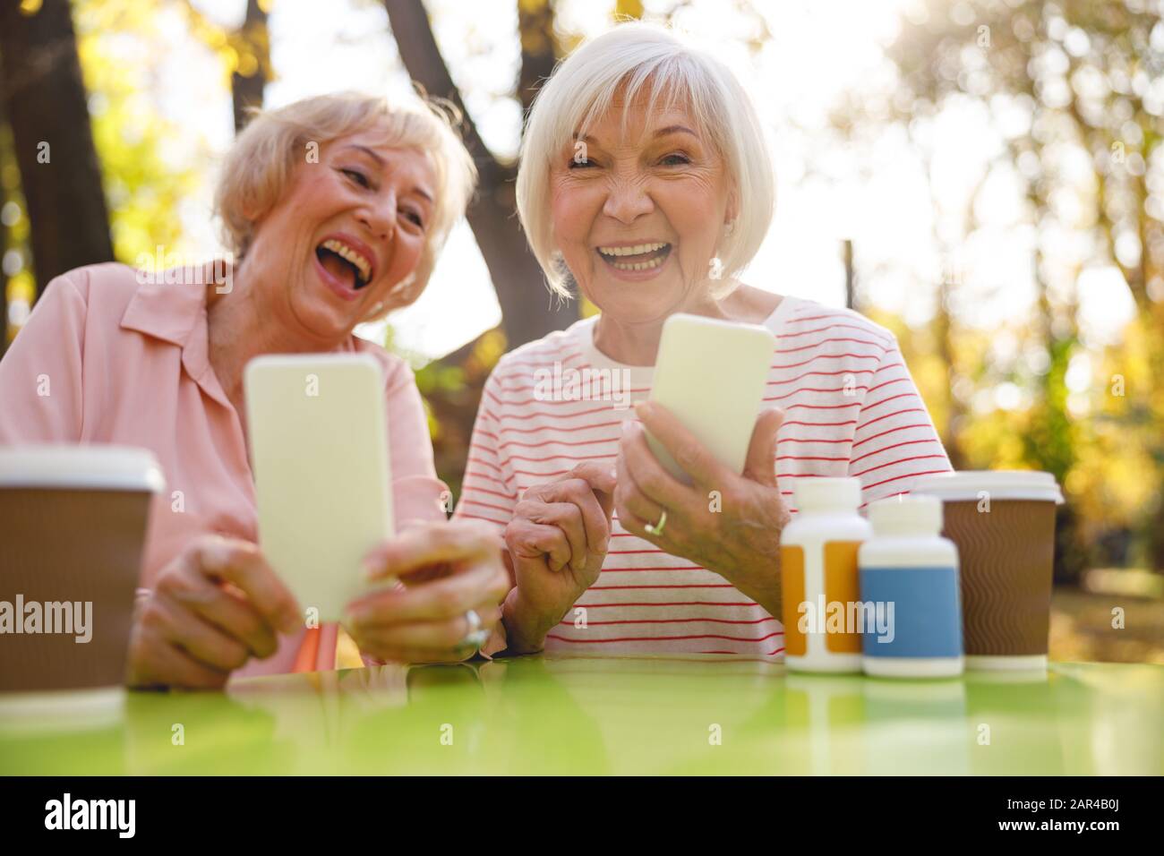 Old friends having fun during their park meeting Stock Photo - Alamy