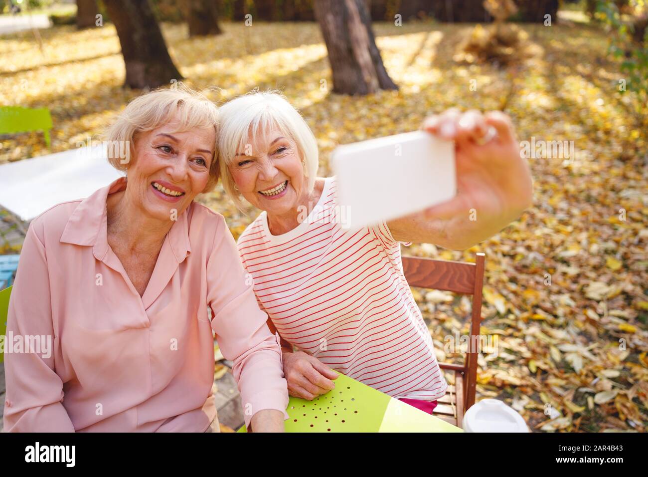 Happy old friends making commemorative picture together Stock Photo - Alamy