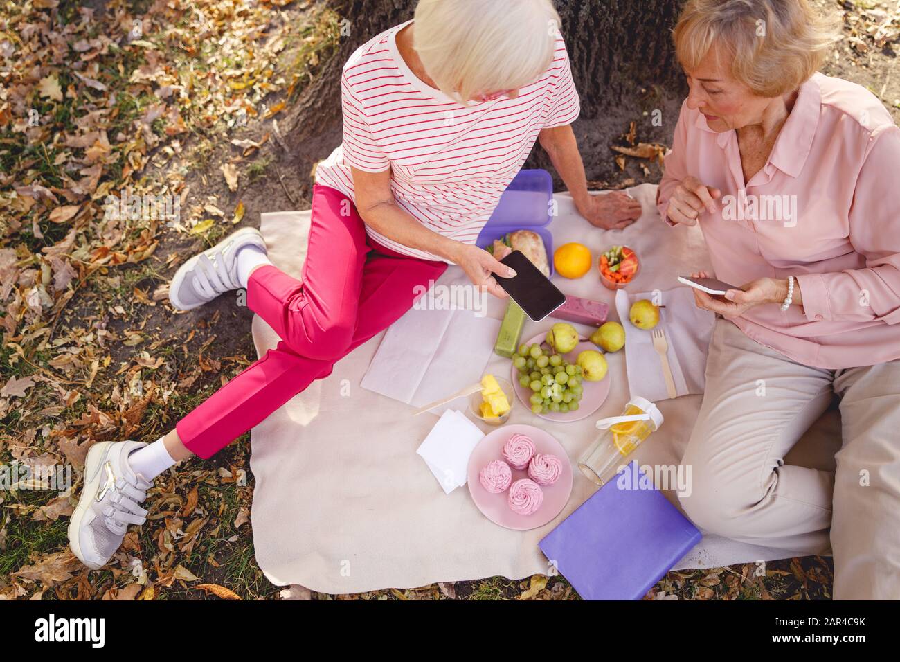 Friends showing each others pictures on their phones Stock Photo - Alamy