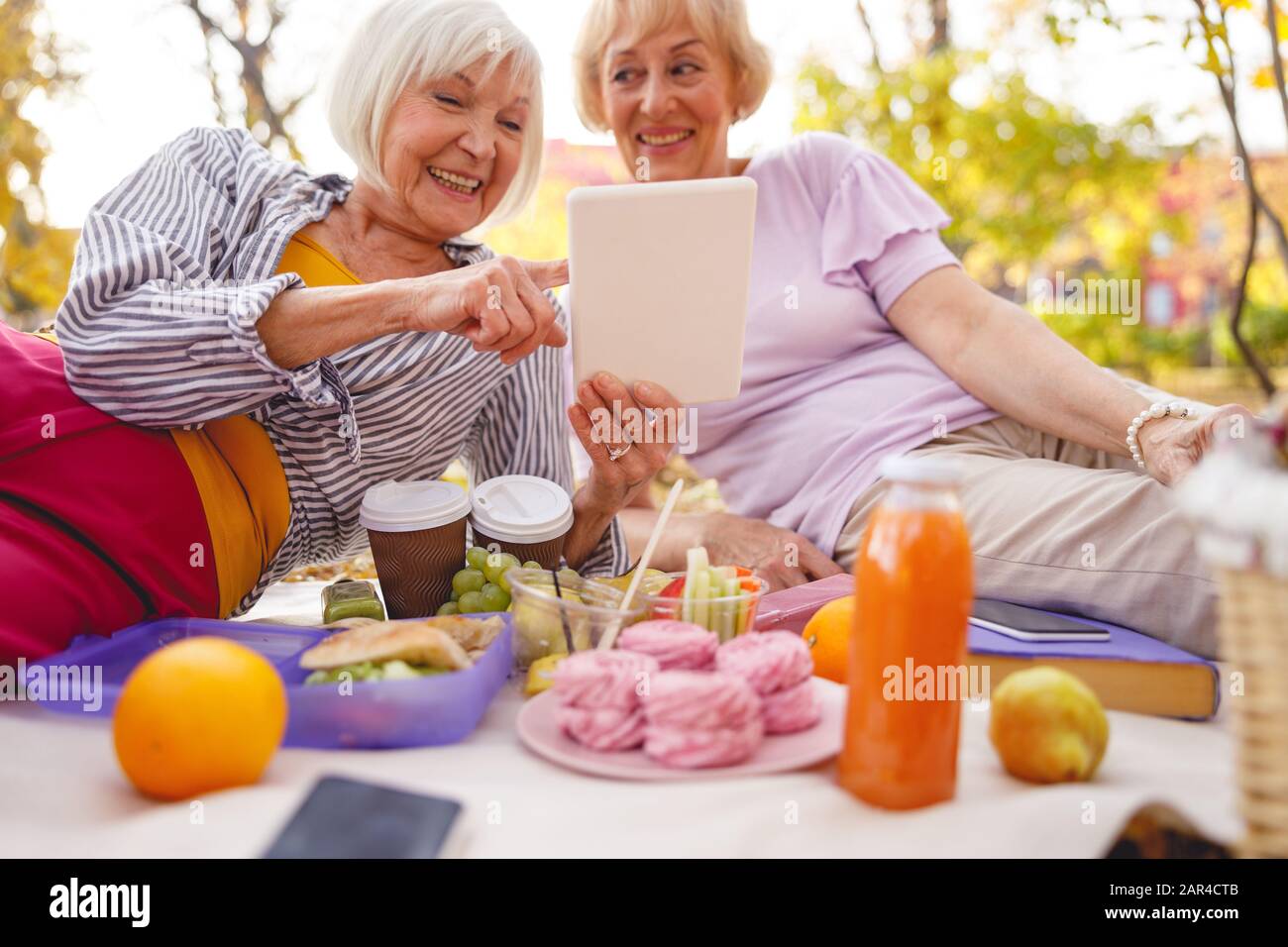 Woman showing new device to her friend Stock Photo - Alamy