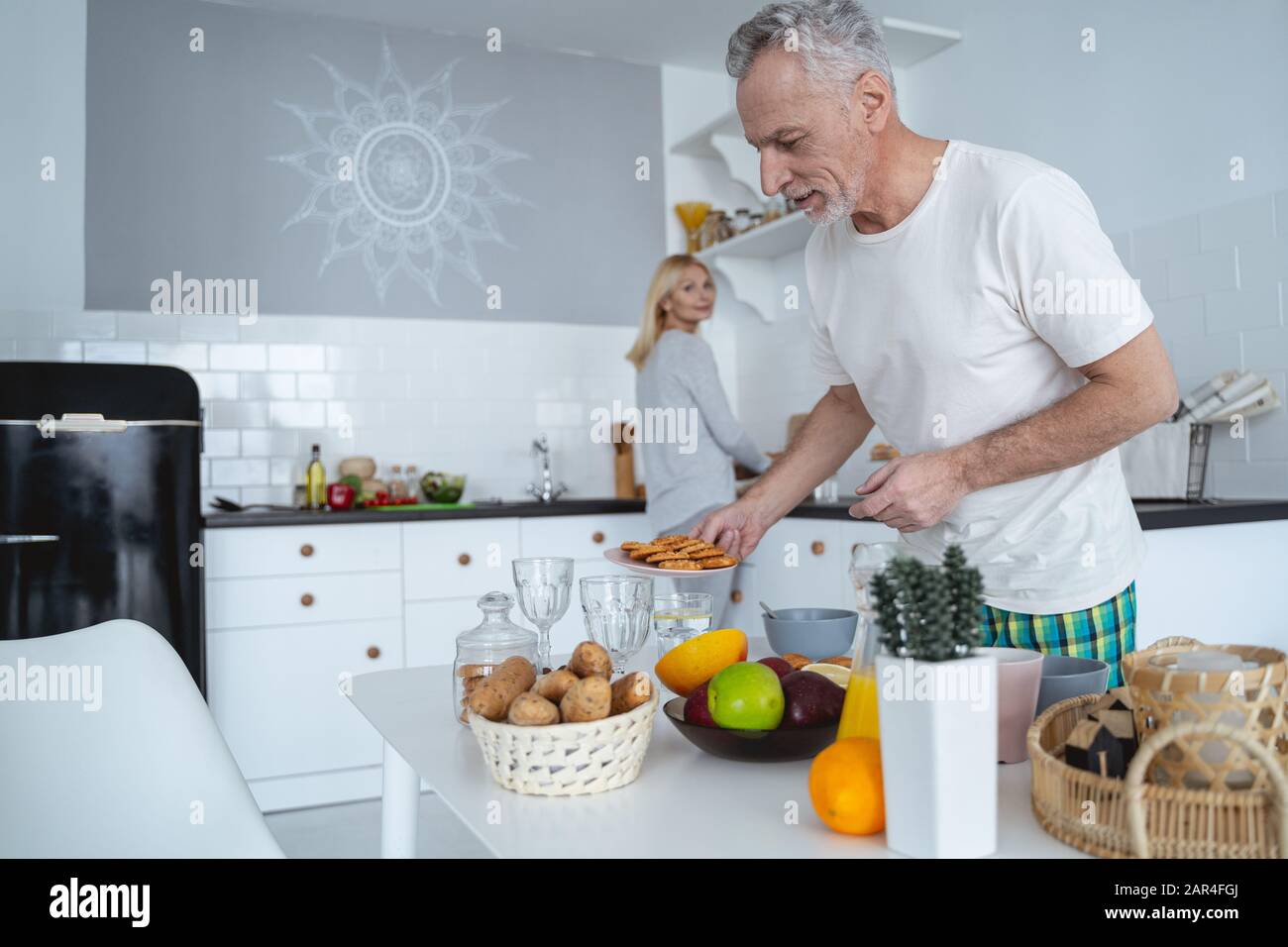 Man laying the table for breakfast stock photo Stock Photo - Alamy