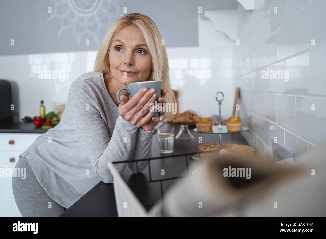 Thoughtful lady with tea in the kitchen stock photo Stock Photo - Alamy
