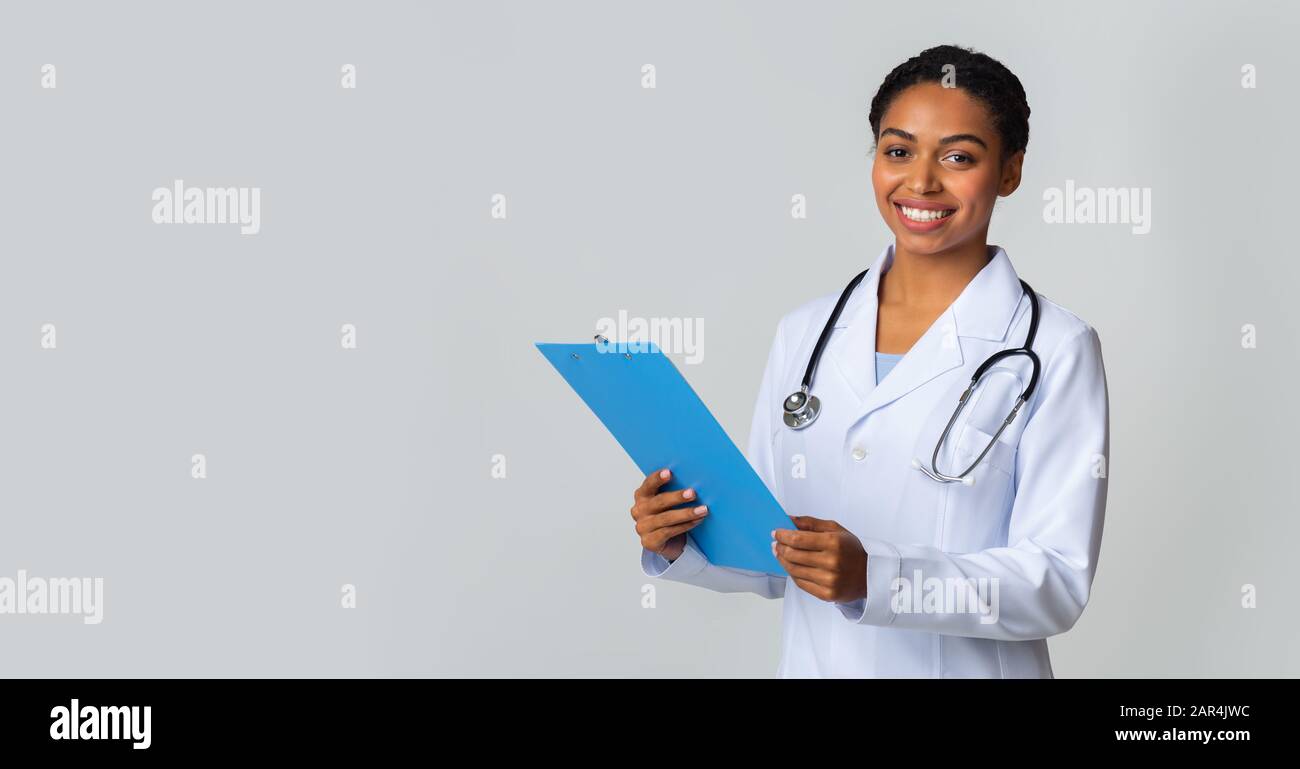 Portrait Of Young Black Female Medical Intern Holding Blue Clipboard ...