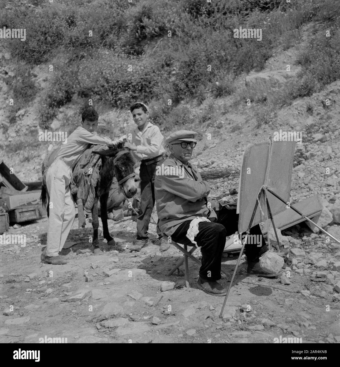 An artist at work on the street in Safad (Safed). Two little boys with ...