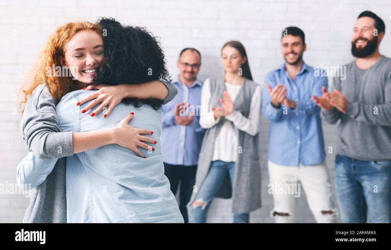 Happy people embracing each other after successful group meeting in ...