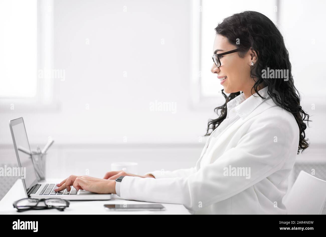Smiling latin woman using her personal computer Stock Photo - Alamy
