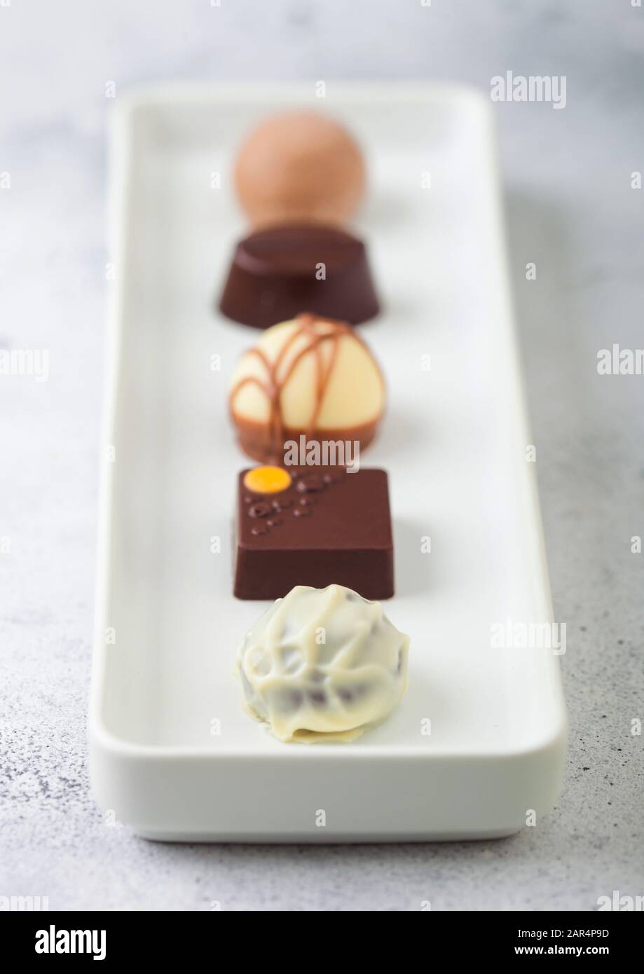 Luxury Chocolate candies selection in white porcelain plate on light ...