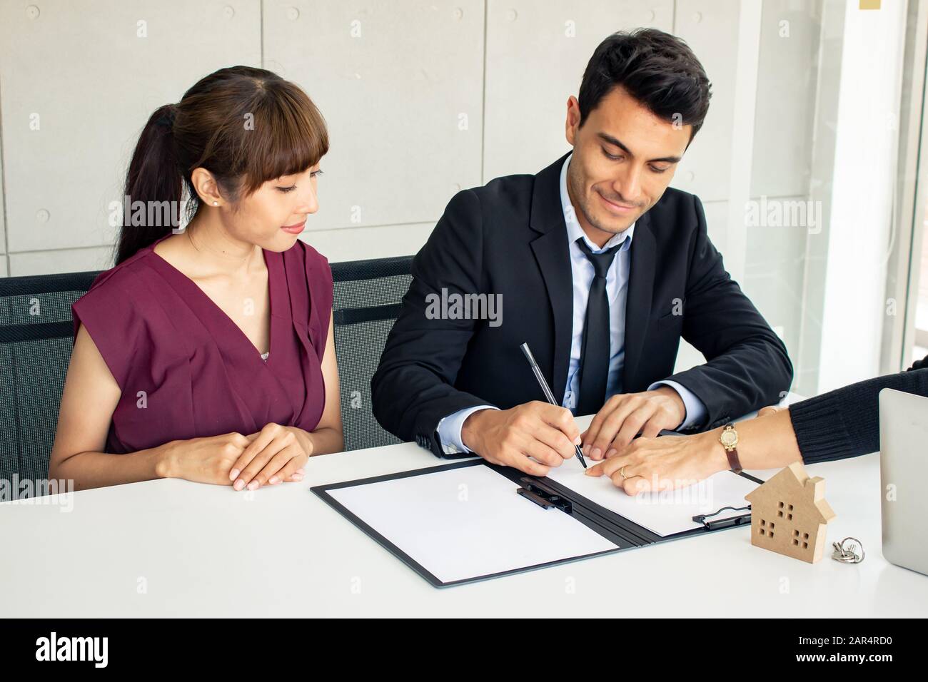 Customers consult with the owner on the contract of house sale. Couples ...