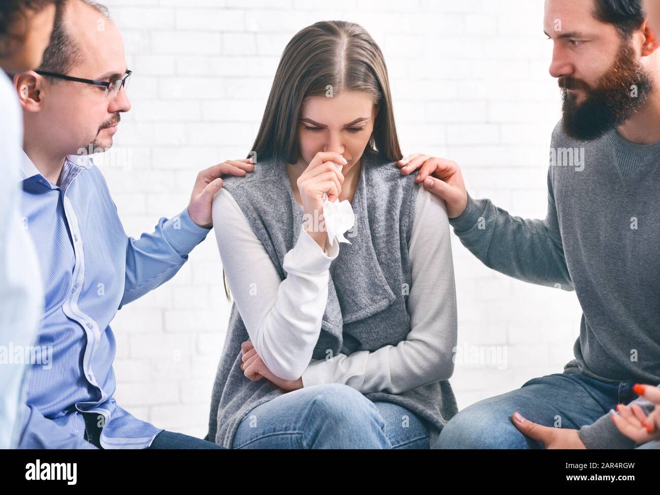 Group members supporting upset woman domestic violence victim on ...