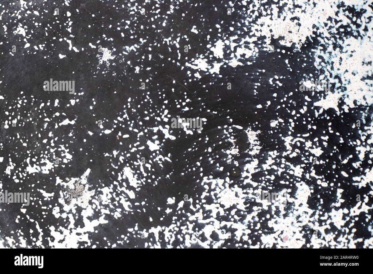 White color stain on black plate background Stock Photo - Alamy