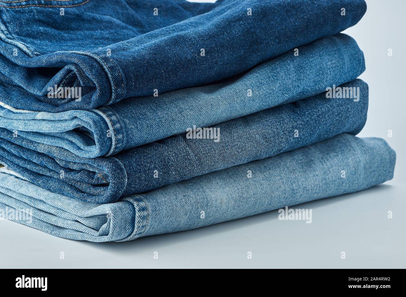Jeans are laid on the table. Denim Fabrics Clothing Background Pile ...