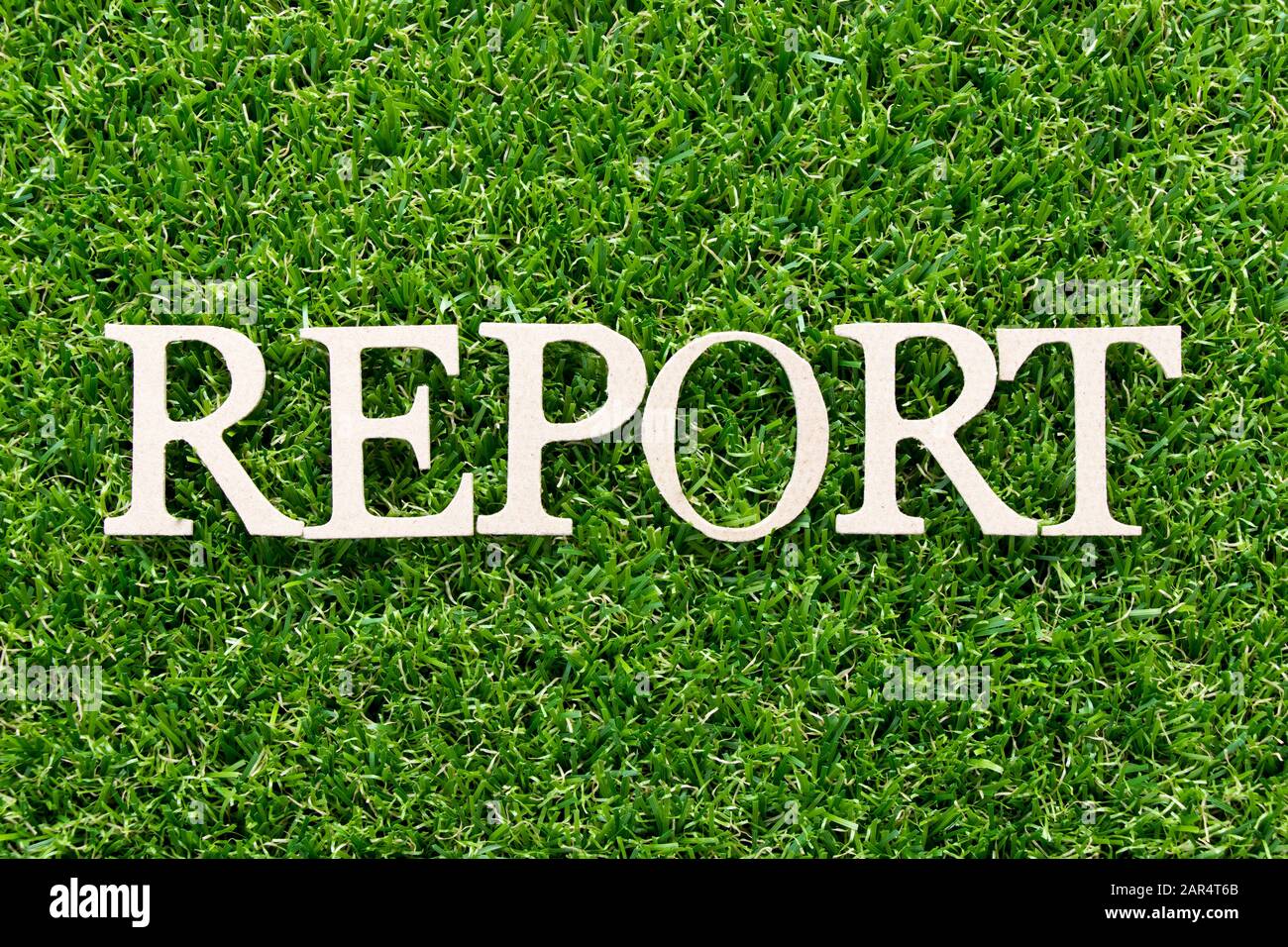 Wood alphabet in word report on artificial green grass background Stock ...