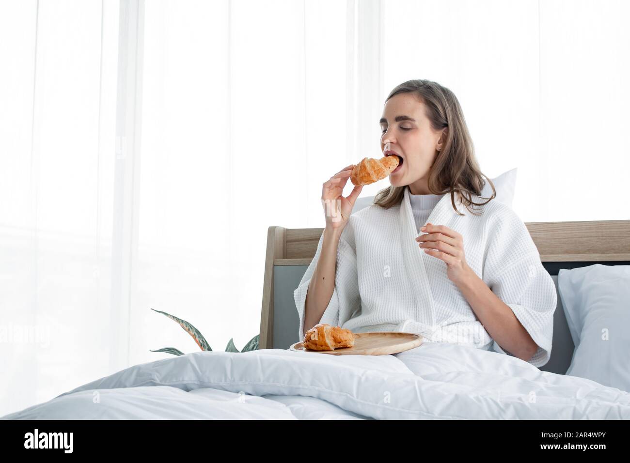 Beautiful young caucasian woman in pajama ready to eat breakfast is ...