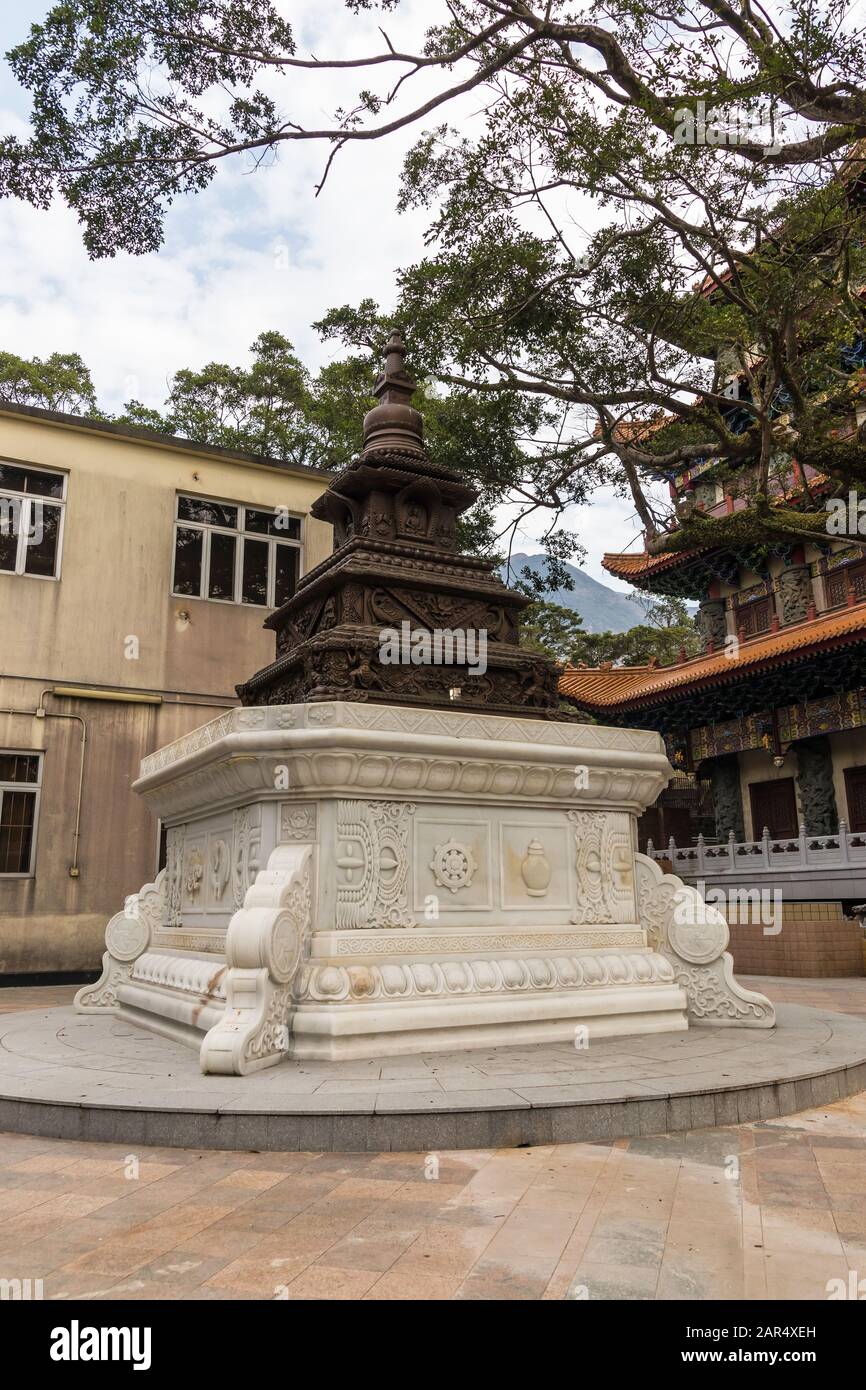 A small stylized stupa with a white marble pedestal in Po Lin Monastery ...