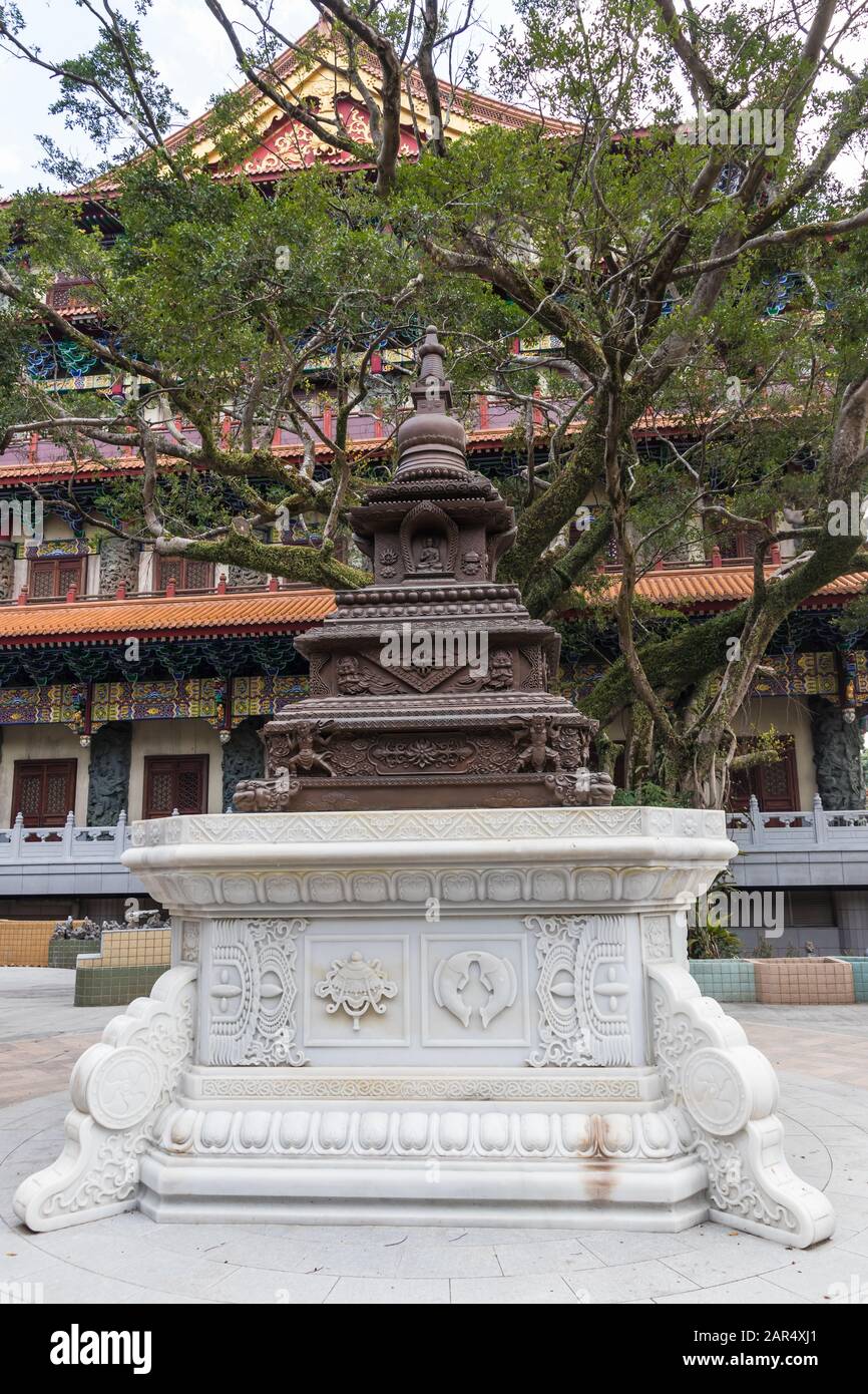 A small stylized stupa with a white marble pedestal in Po Lin Monastery ...