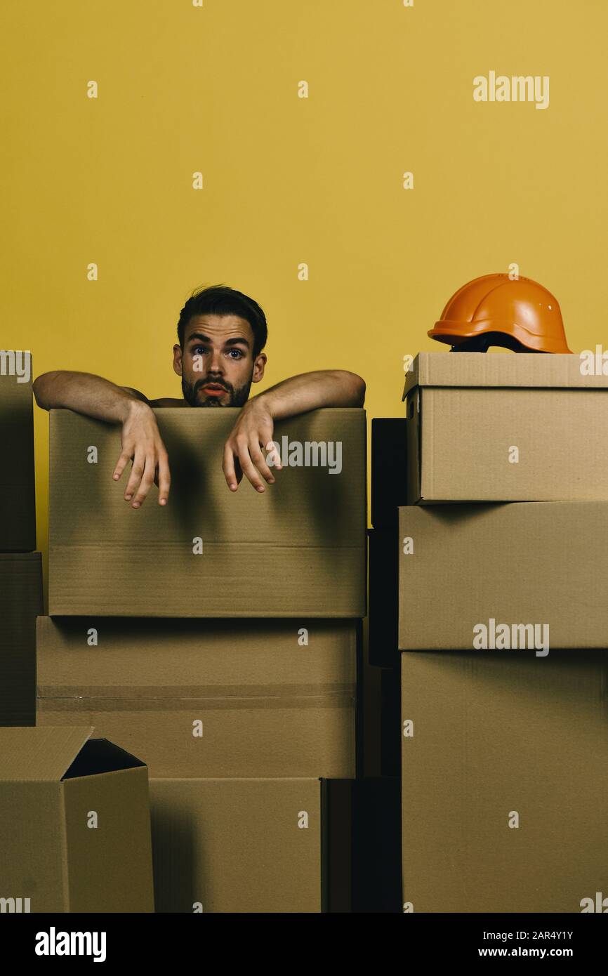 Delivery and moving concept. Guy stands behind cardboard boxes. Macho ...