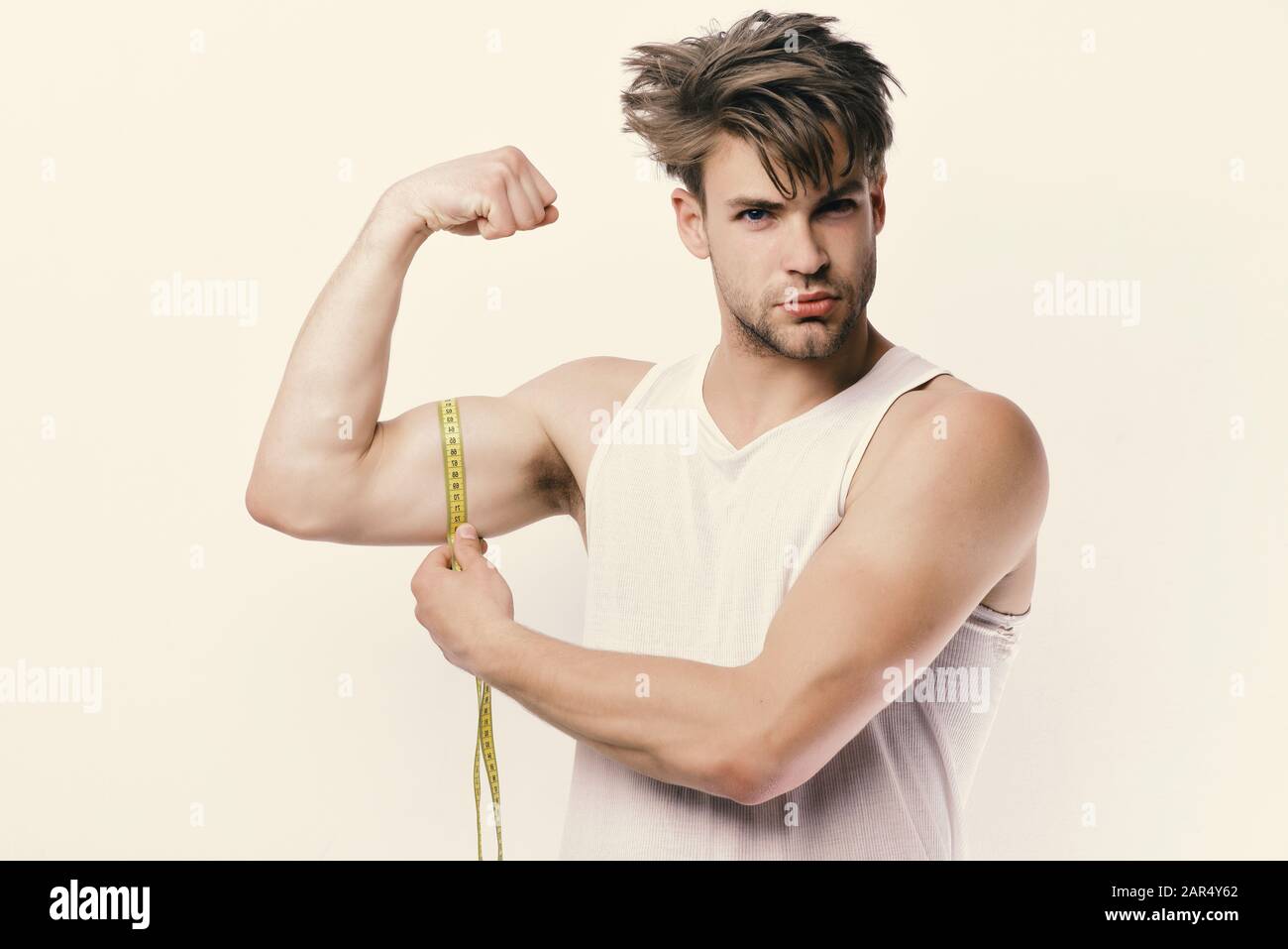Athlete with messy hair showing biceps and triceps. Measurement and ...