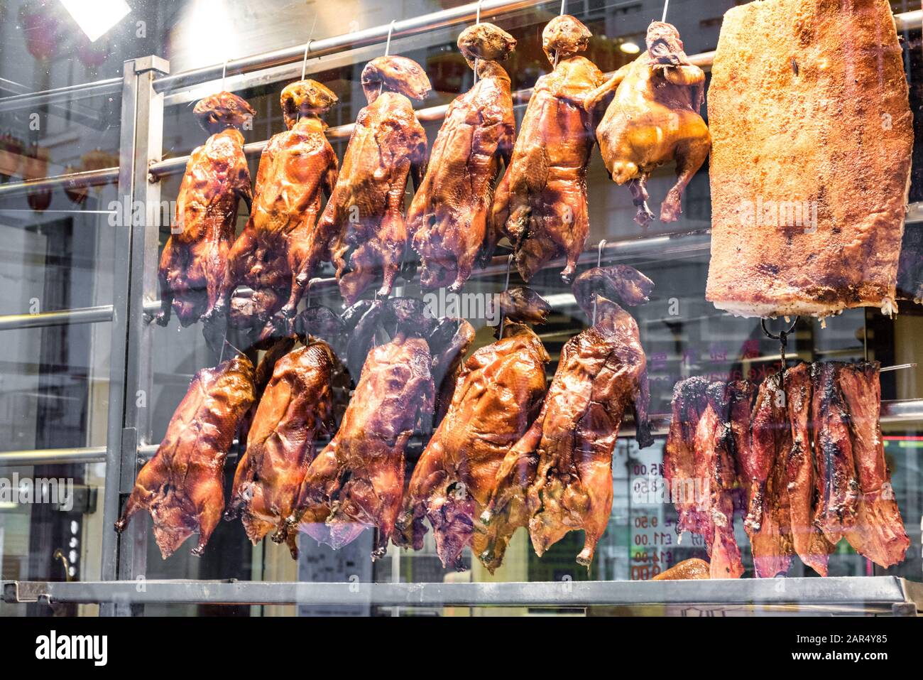 Roast duck and other cooked meat hanging in the front window of a ...