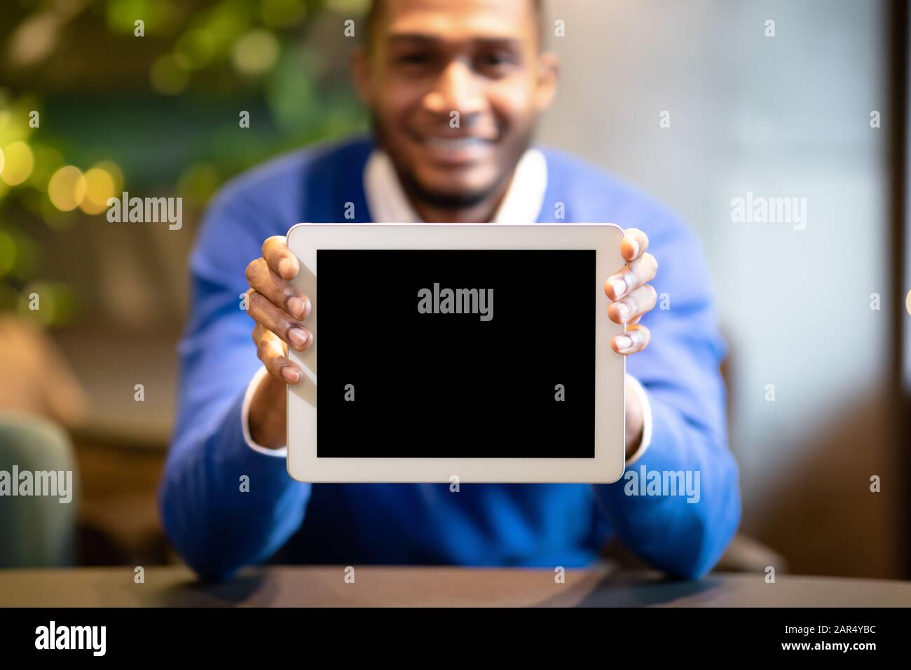 Smiling black man showing blank computer screen Stock Photo - Alamy