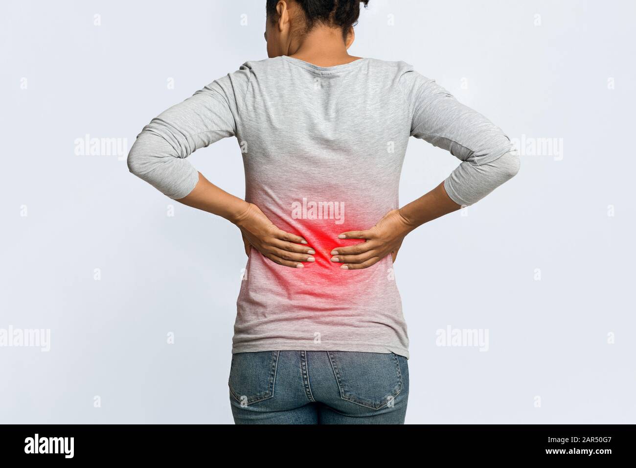 Black woman placing her hands on lower back Stock Photo - Alamy
