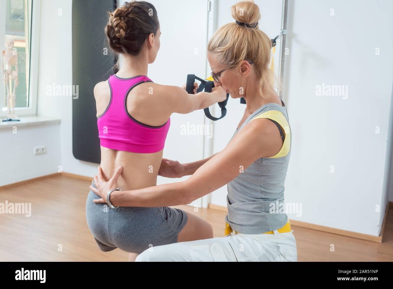 Woman using sling trainer during physical therapy Stock Photo - Alamy