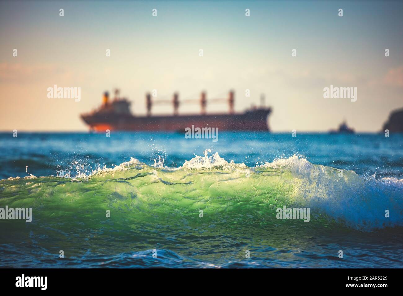 Sailing cargo ship and waves at sunrise. Transportation. Logistics ...