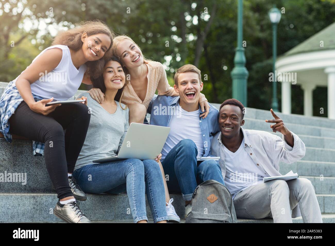 Happy friends students posing while studying in city Stock Photo - Alamy