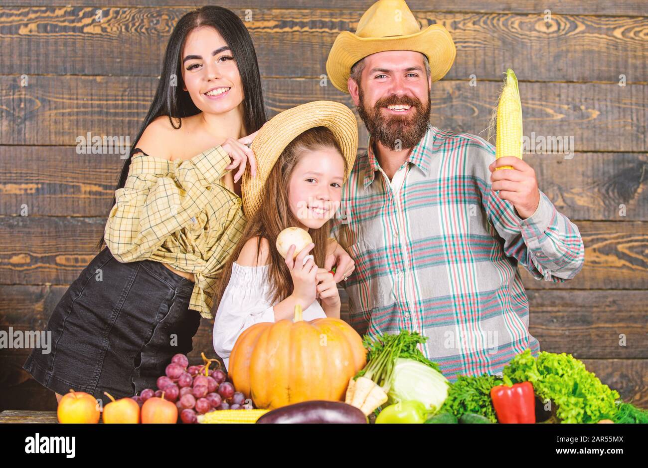 Family farm concept. Family farmers with harvest wooden background ...